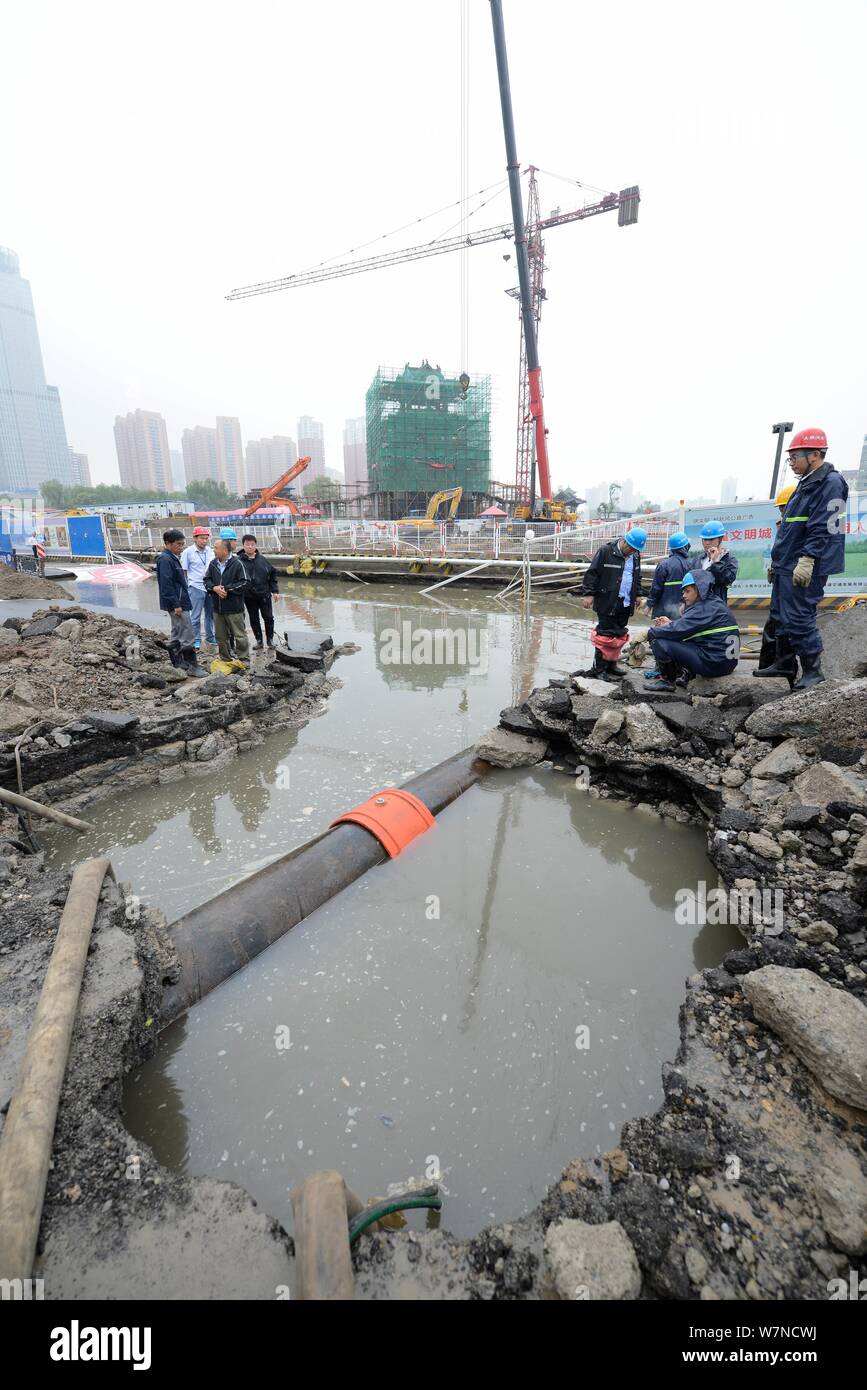 Chinese workers repair a broken water pipe at the accident site after a ...