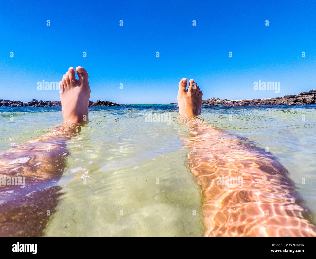 People and ocean outdoor leisure activity - men legs during swim in the ...