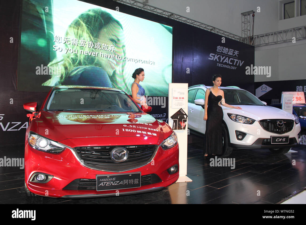 --FILE--Models pose with a Mazda 6 Atenza and a Mazda CX-5 during an ...