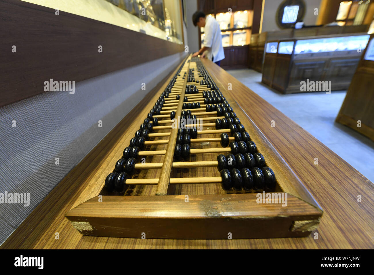 A visitor tries out the 6-meter-long and 0.24-meter-wide huge abacus ...
