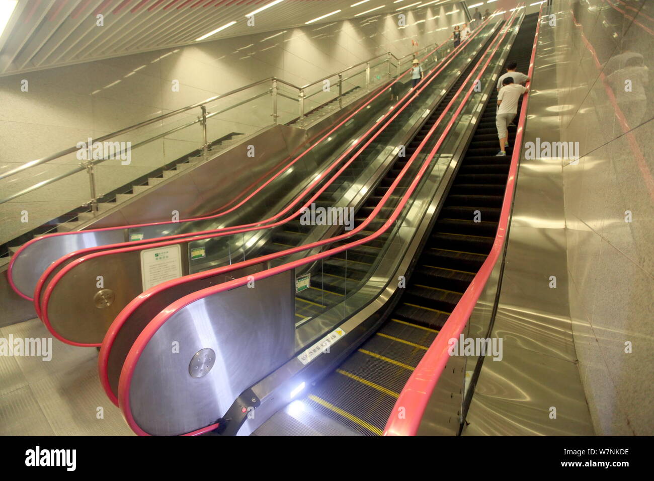 Passengers stand on an escalator at Hongtudi Subway Station which is 60 ...