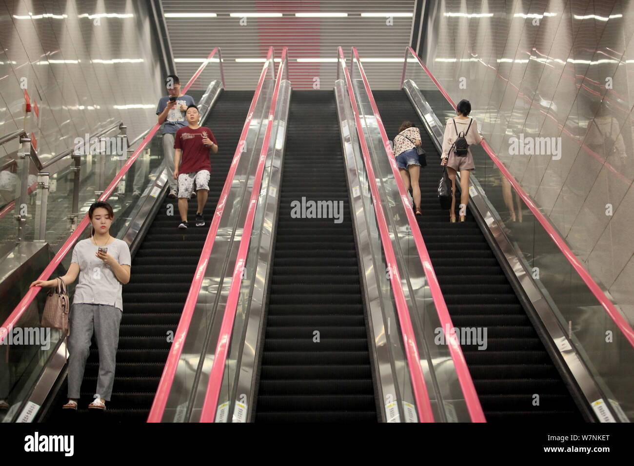 Passengers stand on an escalator at Hongtudi Subway Station which is 60 ...