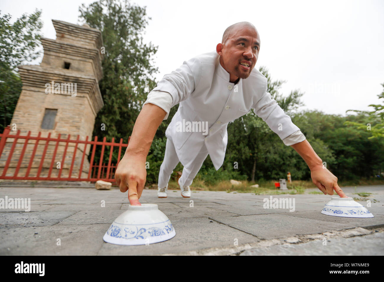 Kungfu master Fan Weipeng does a push-up to support himself by his ...
