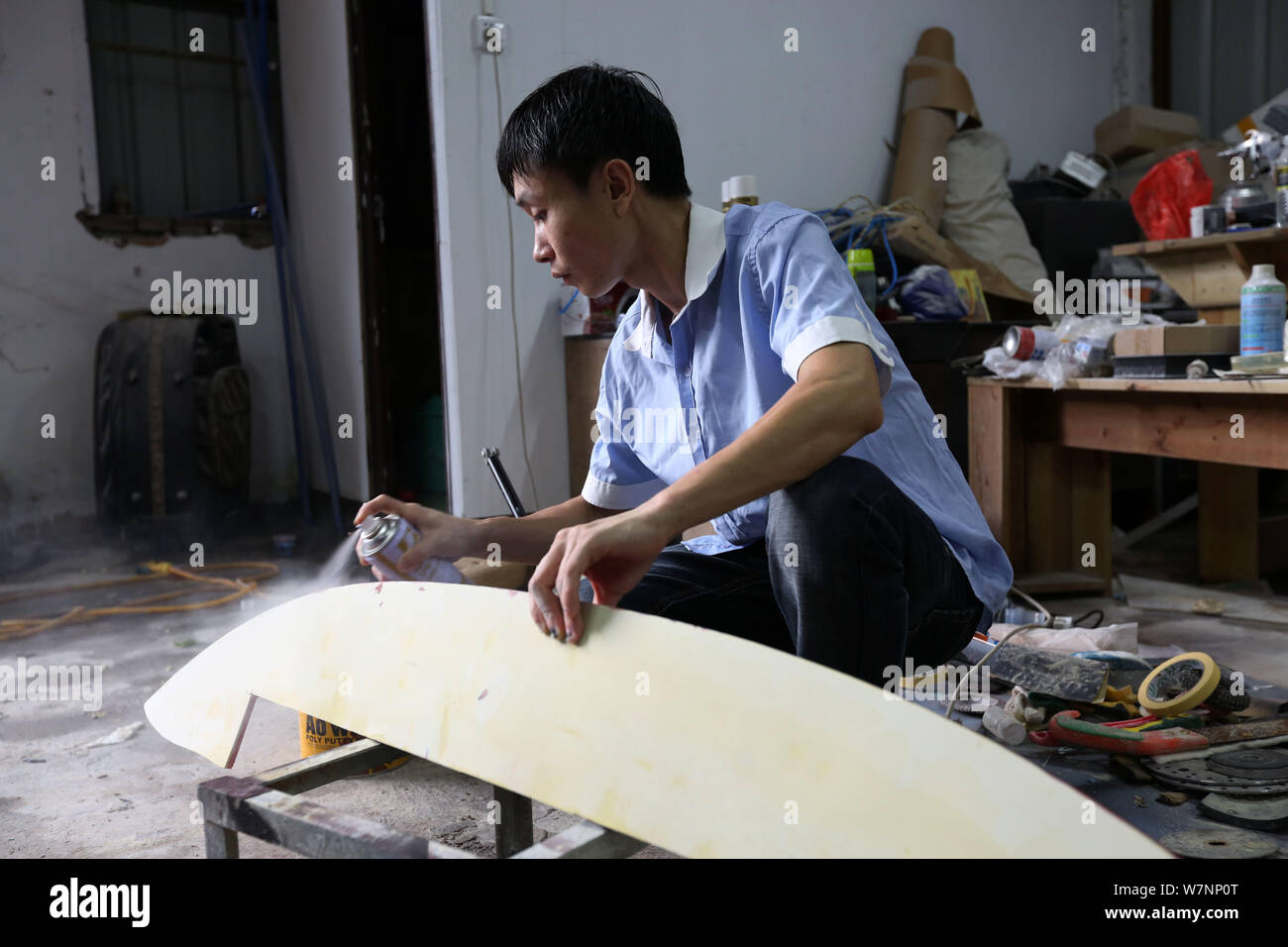 Chinese car enthusiast Chen Yinxi sprays paint his homemade electric ...