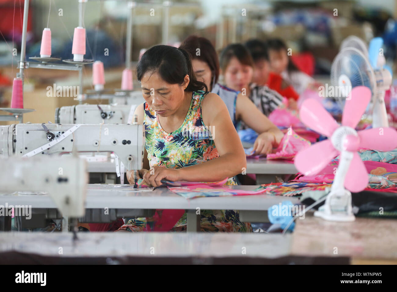 --FILE--Female Chinese workers sew clothes at a garment factory in Jinjiang city, southeast ...