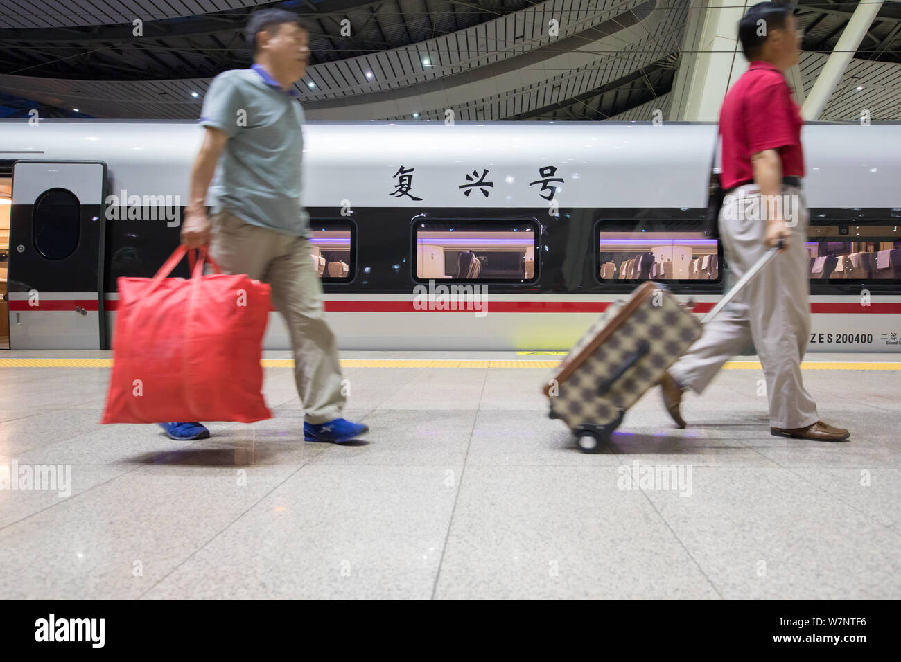 --FILE--Passengers walk past a "Fuxing" high speed bullet train on ...