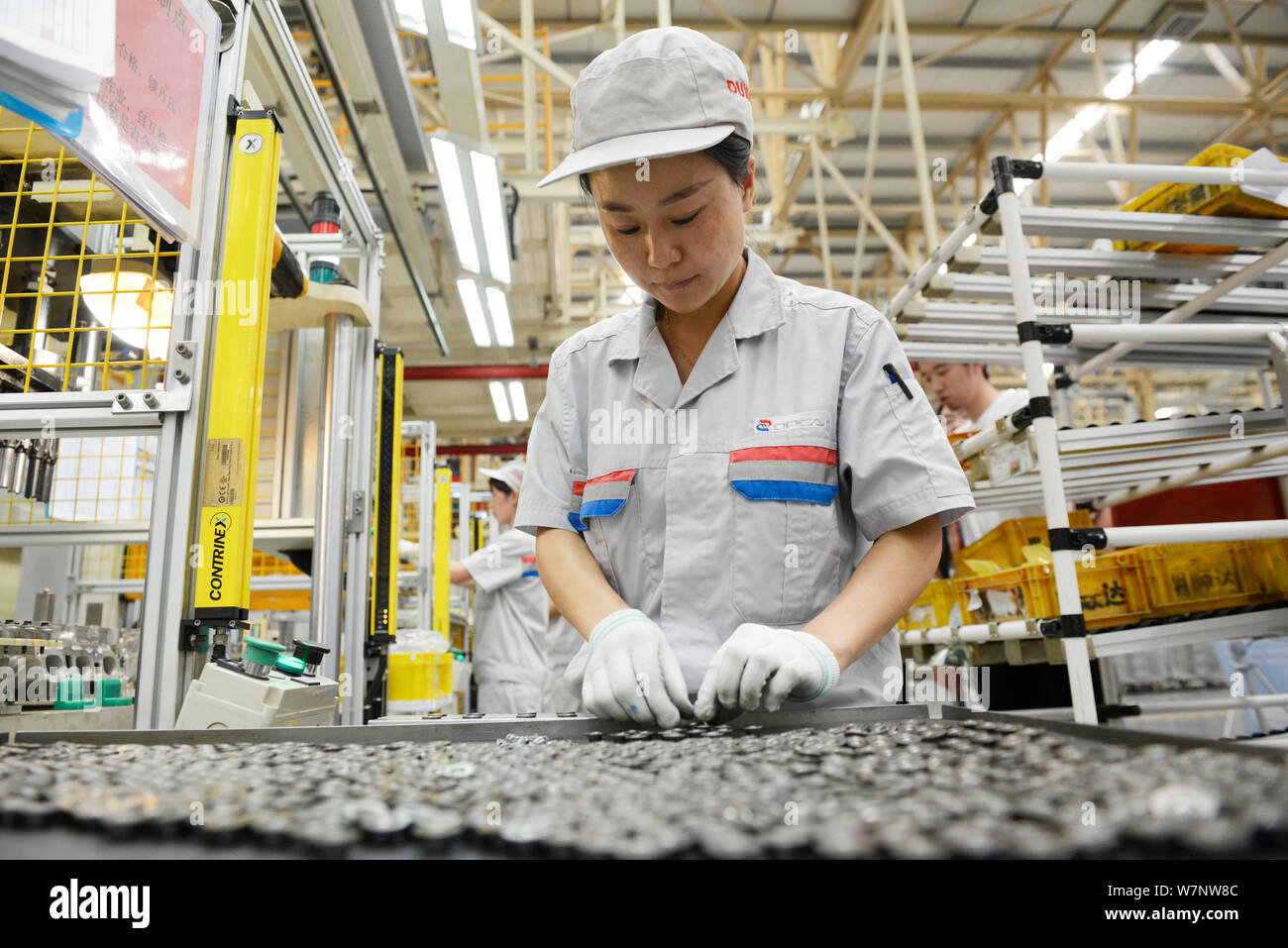--FILE--A female Chinese worker checks car parts at an auto plant in ...