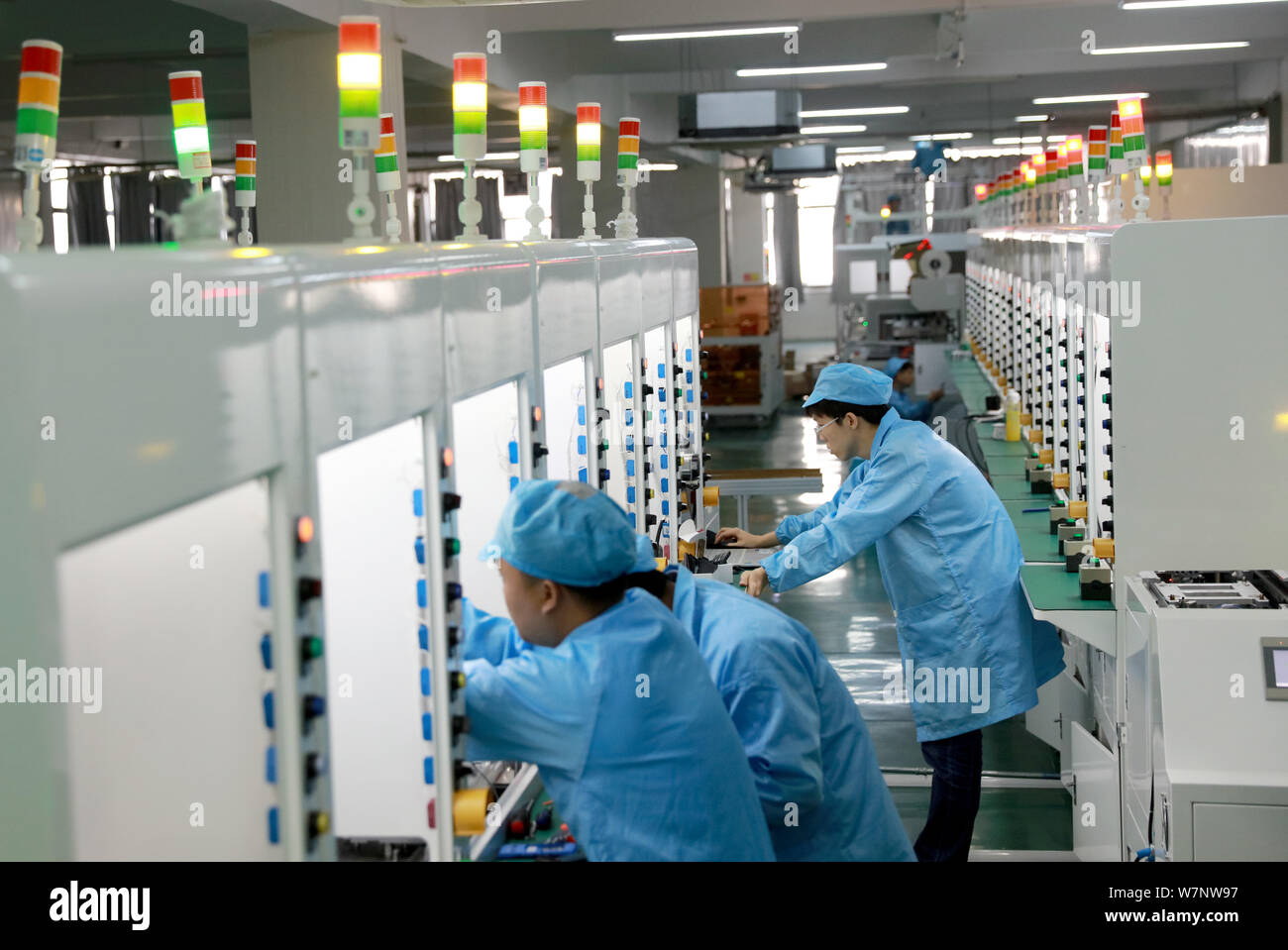 --FILE--Chinese workers process electronic products on the assembly line at a factory in Huaying ...