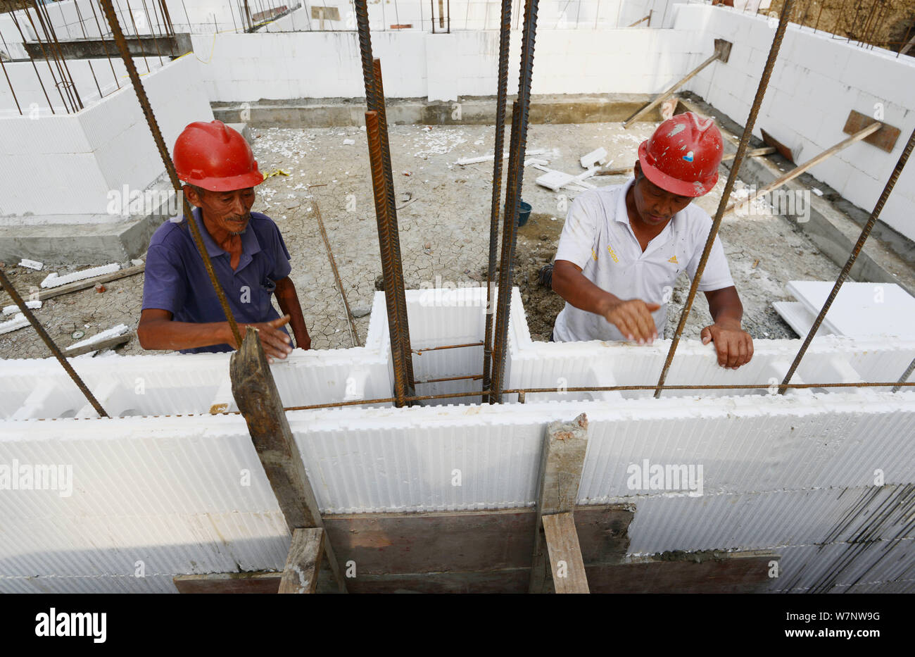 --FILE--Chinese workers build a house with molded expanded polystyrene ...