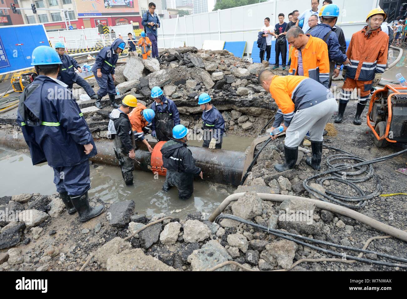 Chinese workers repair a broken water pipe at the accident site after a ...