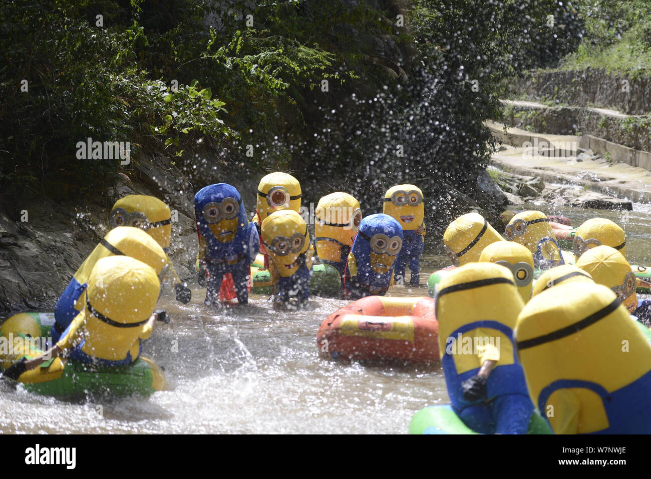 Tourists in Minion costumes enjoy leisure time on rubber rafts at a ...