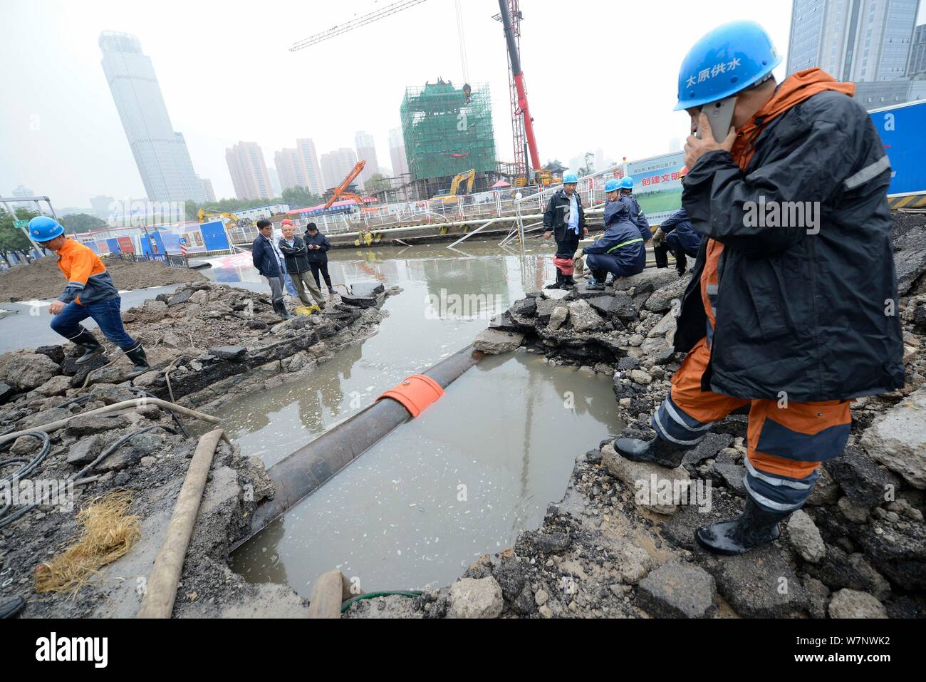 Chinese workers repair a broken water pipe at the accident site after a ...