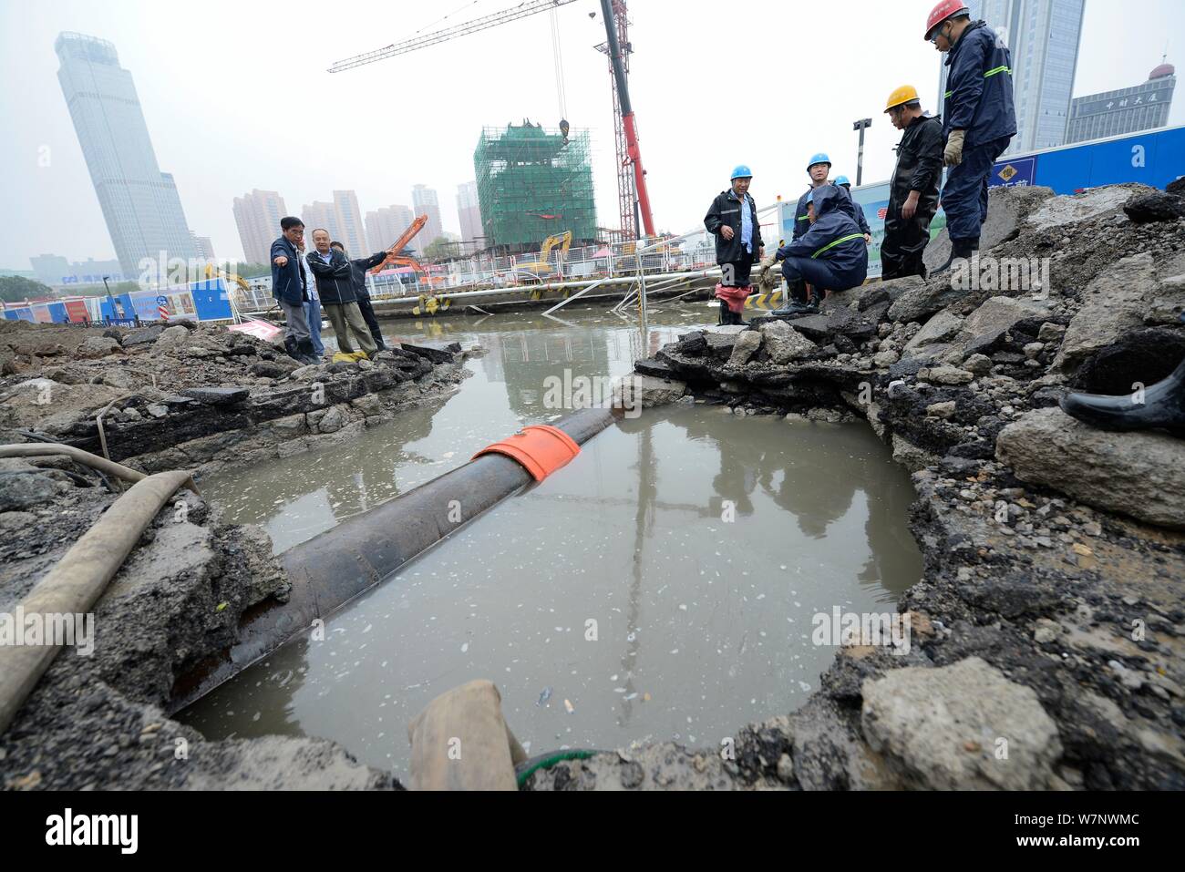 Chinese workers repair a broken water pipe at the accident site after a ...