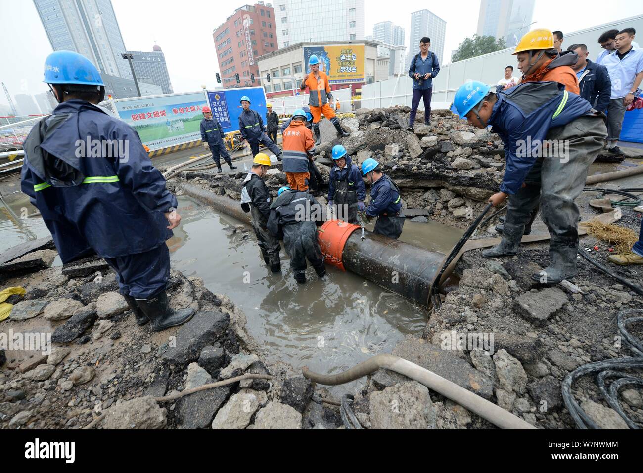 Chinese workers repair a broken water pipe at the accident site after a ...