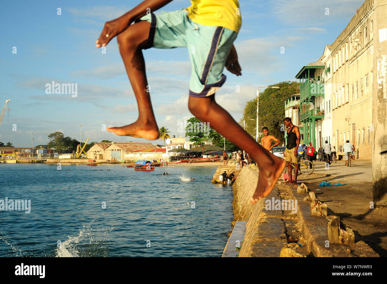 Legs of local man jumping into the water from jetty in Port Stone ...