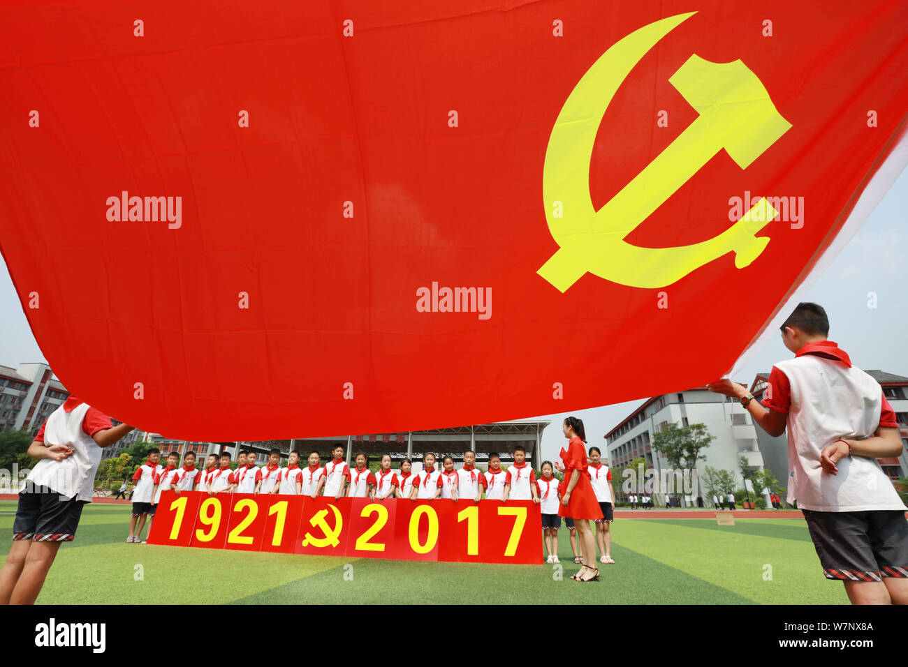 A teacher explains details of the flag of the Communist Party of China ...