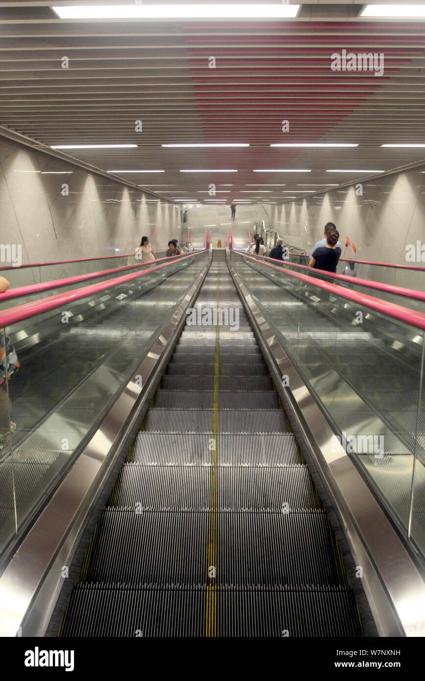 Passengers stand on an escalator at Hongtudi Subway Station which is 60 ...