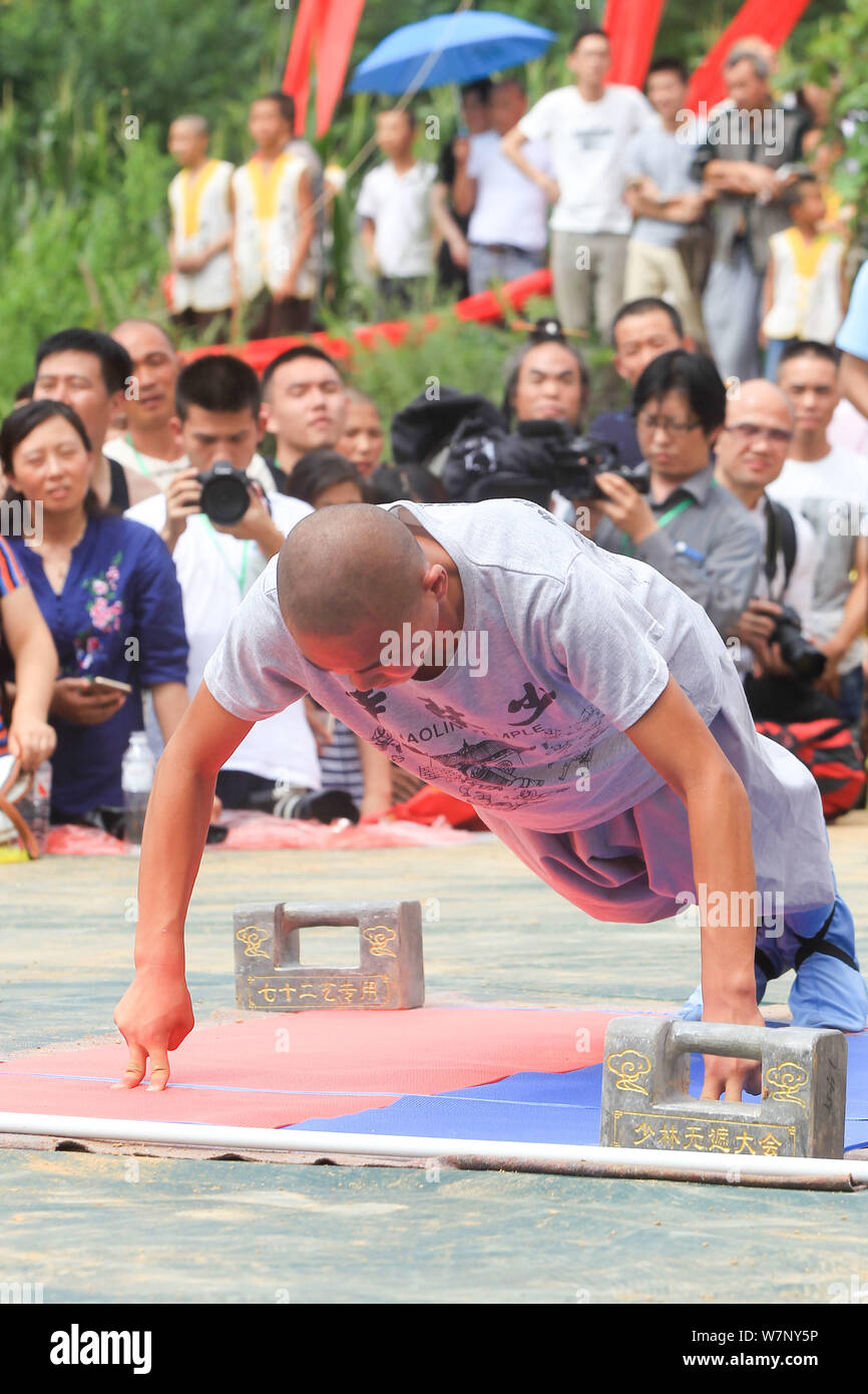 A competitor does a push-up to support himself by his index fingers and ...
