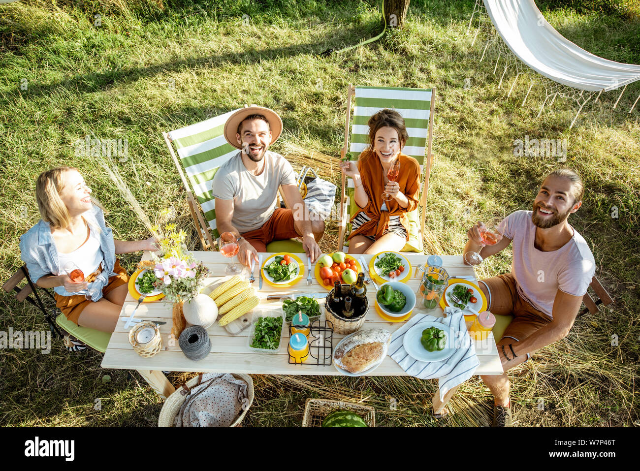 Group of a young friends having festive lunch in the beautifully ...
