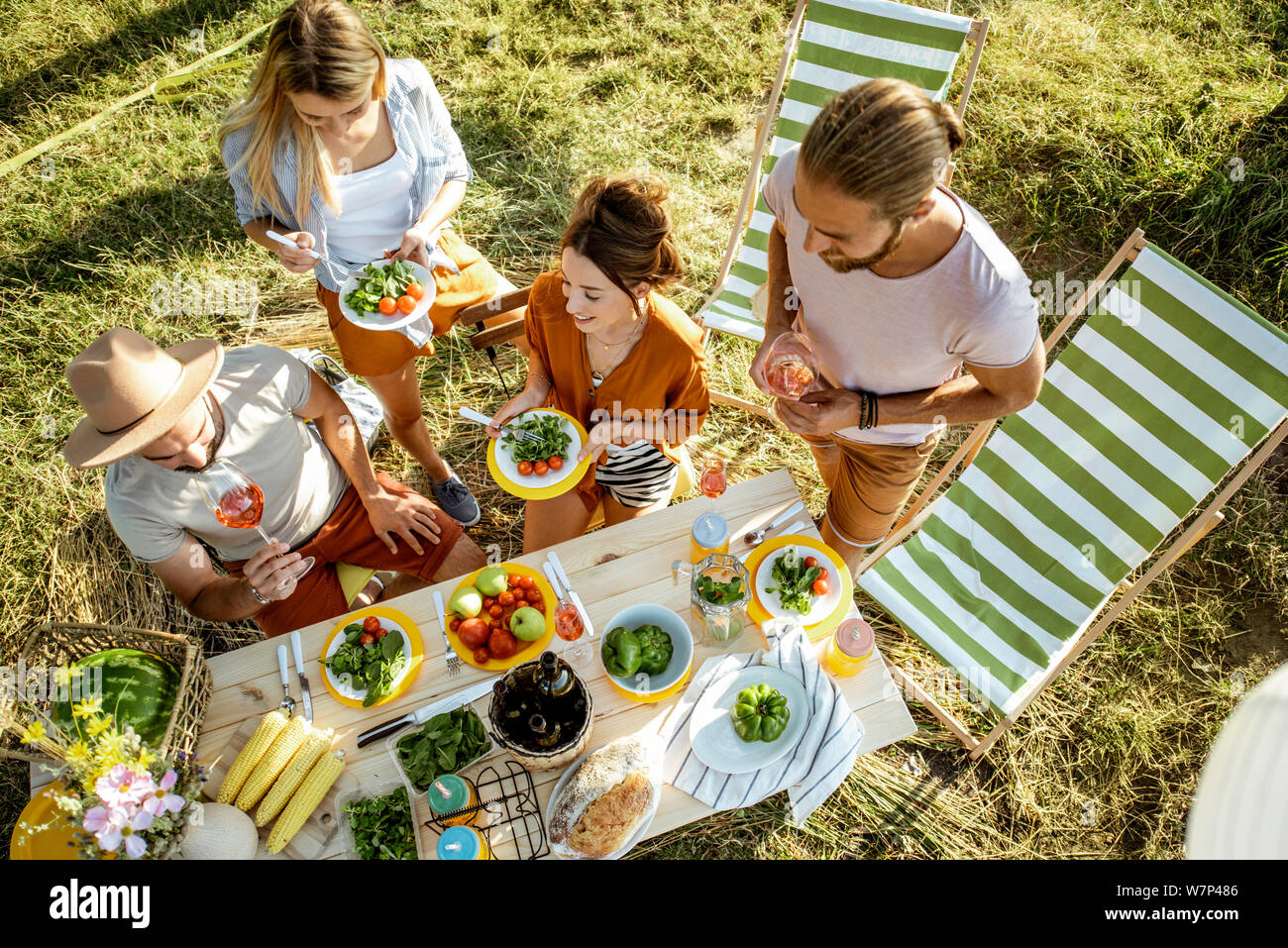Group of a young friends having festive lunch in the beautifully ...