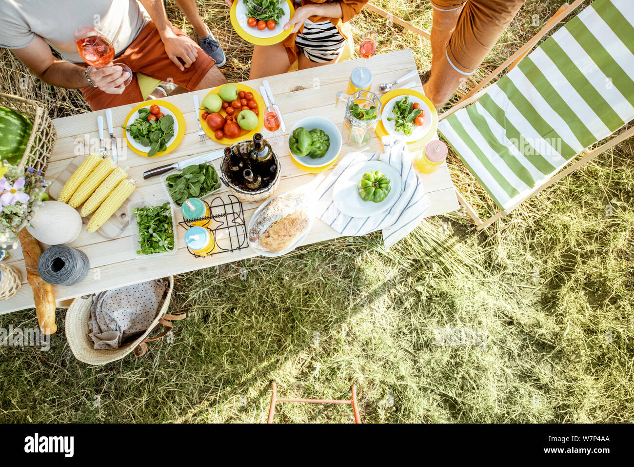People having festive lunch in the garden with healthy food on the ...