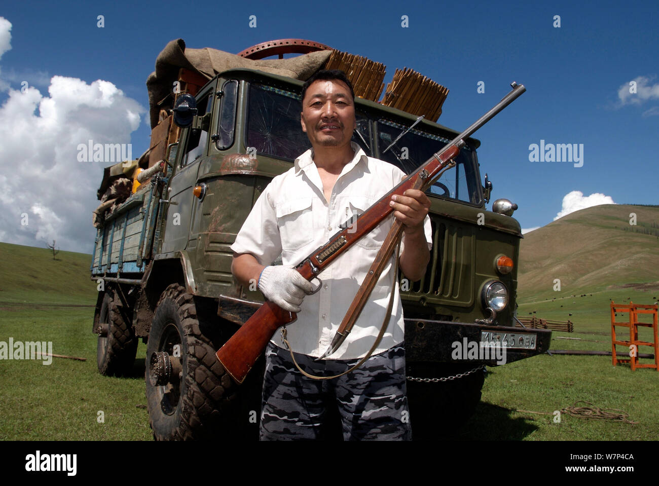 A driver armed with his groundhog rifle poses proudly in front of his ...