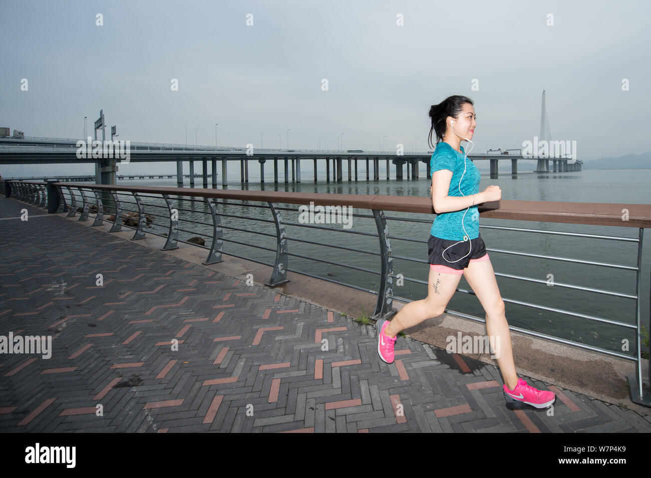 A Chinese running enthusiast jogs along the past the Shenzhen Bay ...