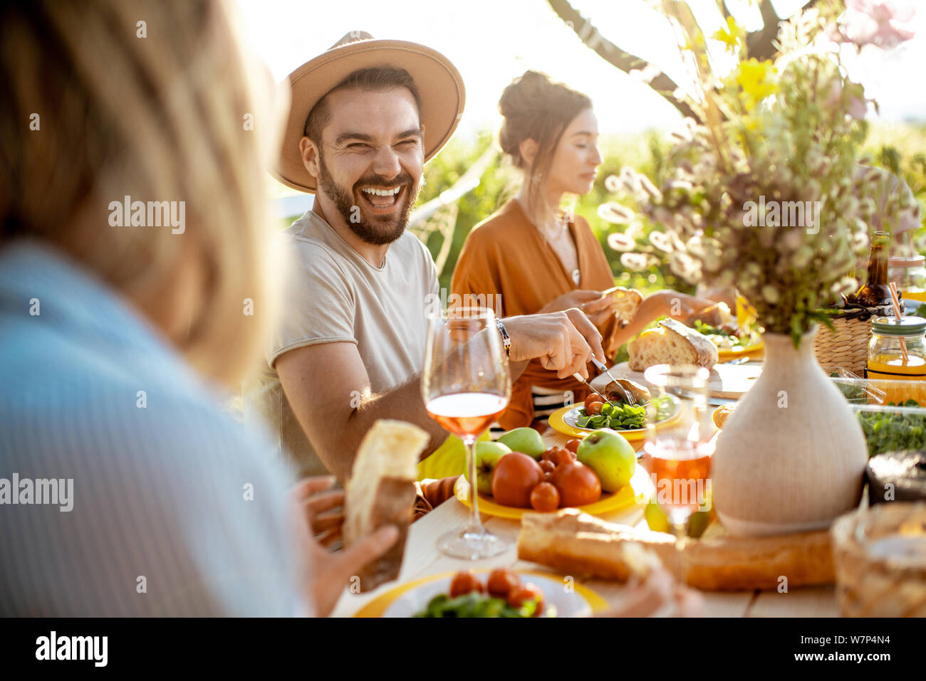 Young and happy people having festive lunch at the beautifully ...