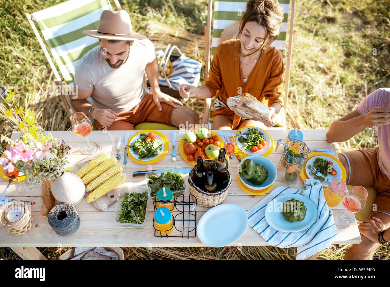 People having festive lunch in the garden with healthy food on the ...