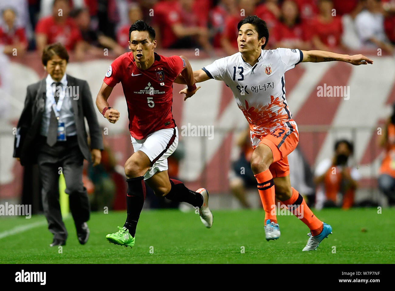 Tomoaki Makino of Japan's Urawa Red Diamonds, left, challenges Chung ...