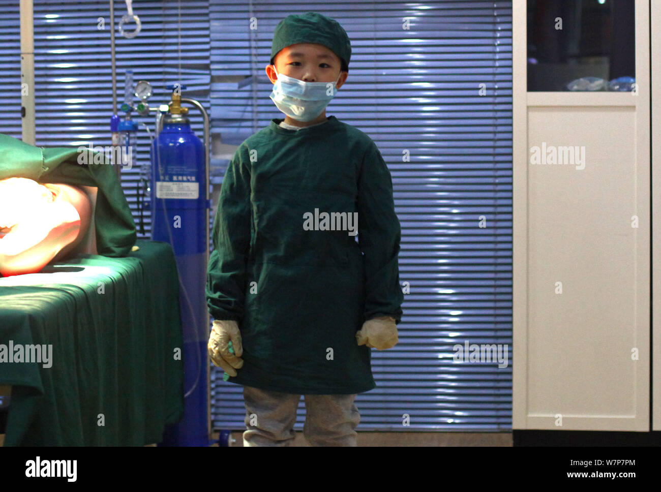 Five-year-old Wang Xingchun dressed in a doctor's uniform poses for ...