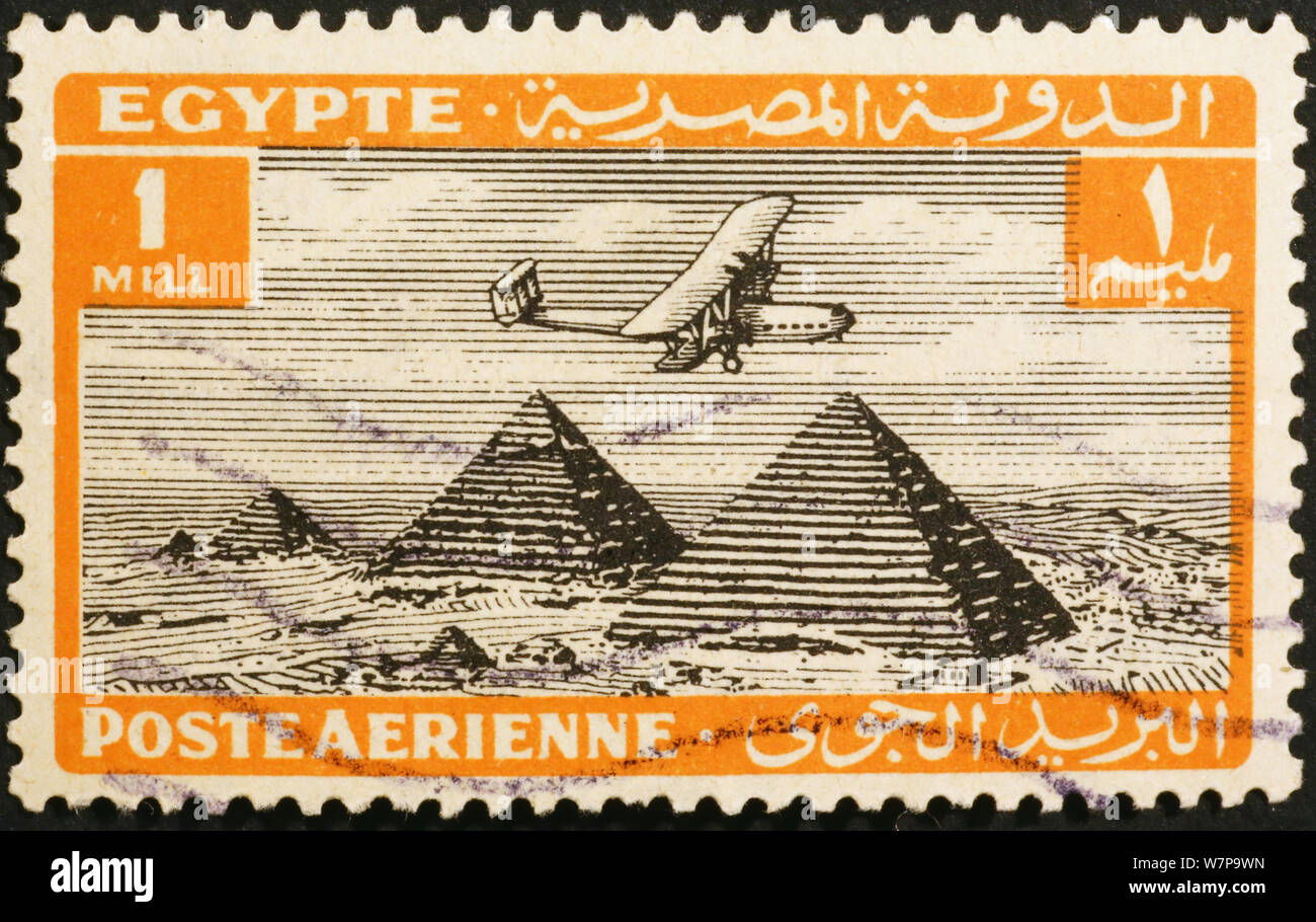 Biplane flying over pyramids in old egyptian postage stamp Stock Photo ...