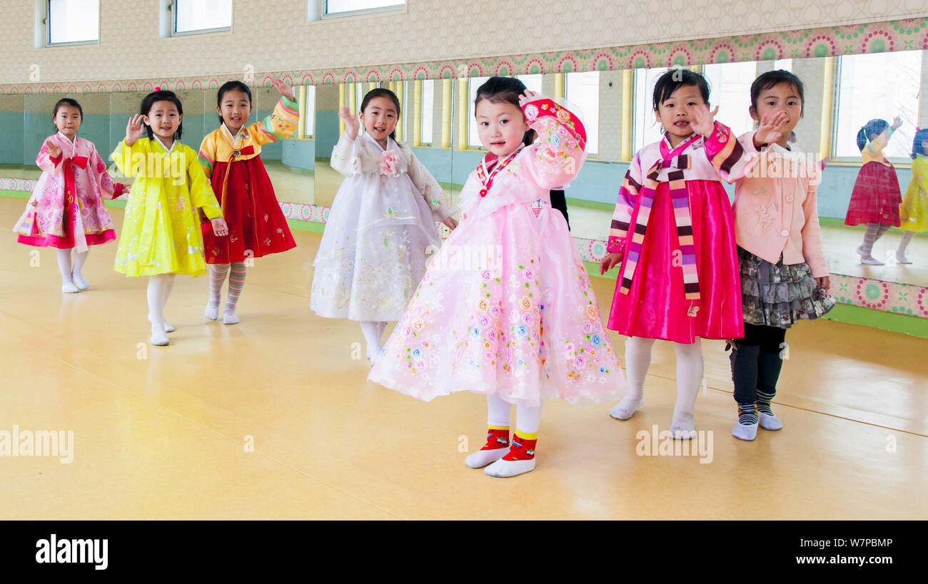 Children in traditional clothes, waving to camera, Mangyongdae ...