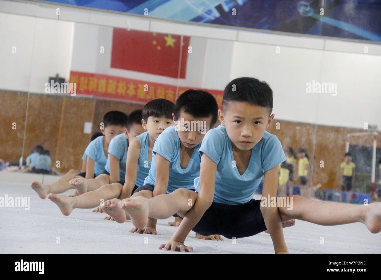 Young Chinese boys bend their bodies to keep balance with their hands ...