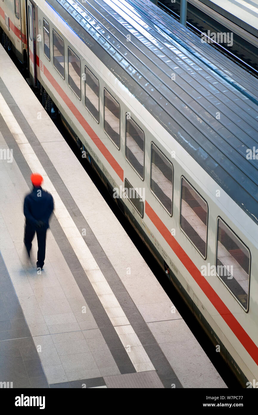 Train pulling into new modern main railway station, with man on ...