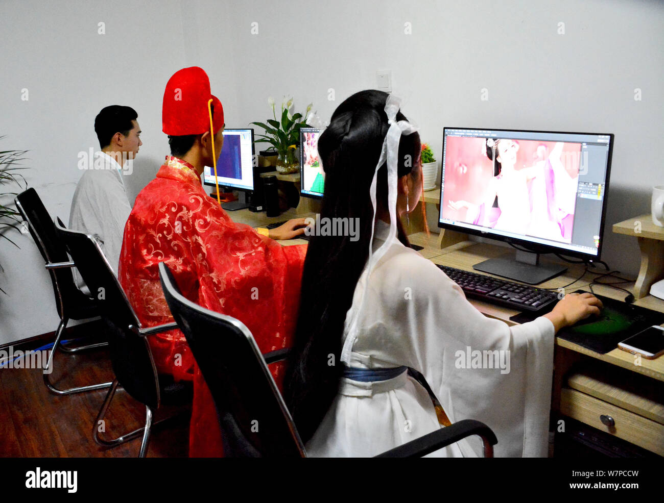 Chinese employees dressed in traditional costumes are pictured as they ...