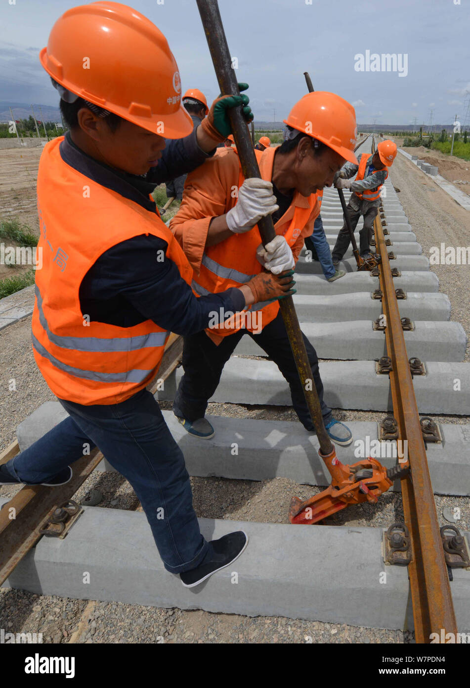 Chinese workers labor at the construction site to lay the tracks on the ...
