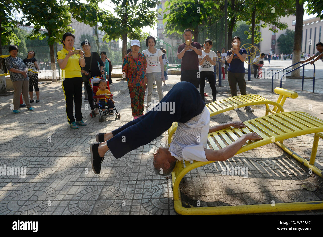 80-year-old Chinese man Wang Zhongwei is pictured as he stands upside-down on a body-building ...