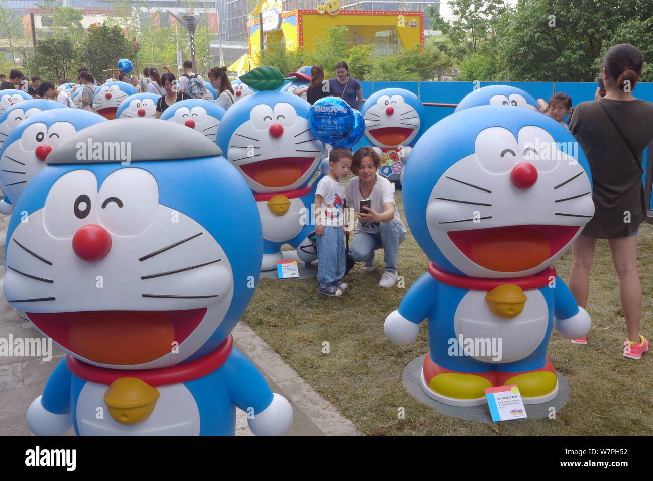 Visitors take selfies with models of Doraemon, a famous Japanese ...