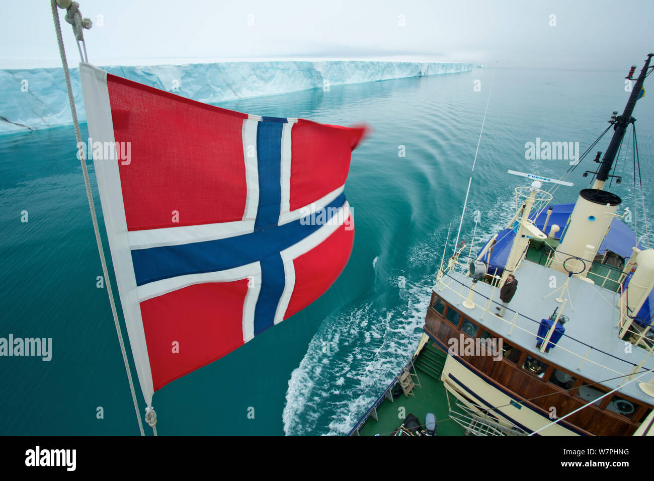 Norwegian flag set on M/S Stockholm and ice front of Brasvellbreen seen ...