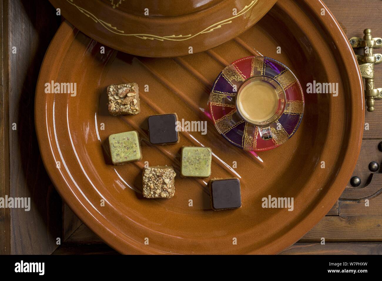 Overhead shot of different types of square-shaped sweets with tea on a ...