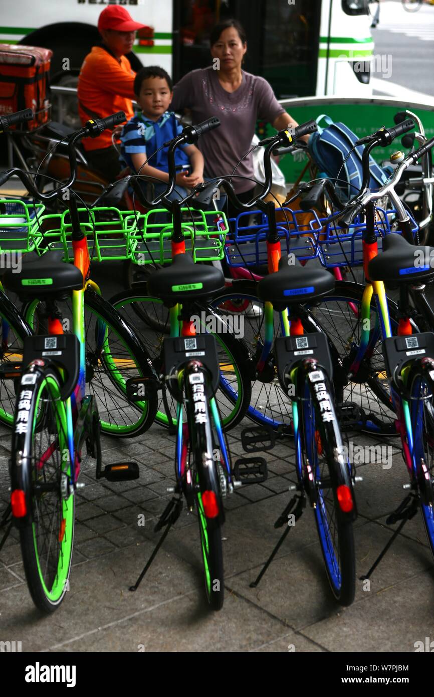 Local residents look at seven-colored shared bicycles of Chinese bike ...