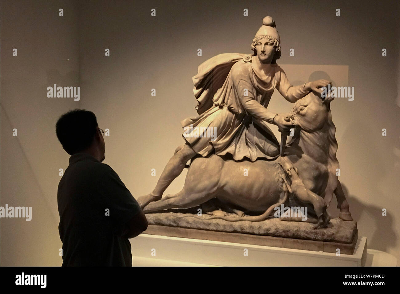 A visitor looks at the marble statue of Mithras displayed during the ...