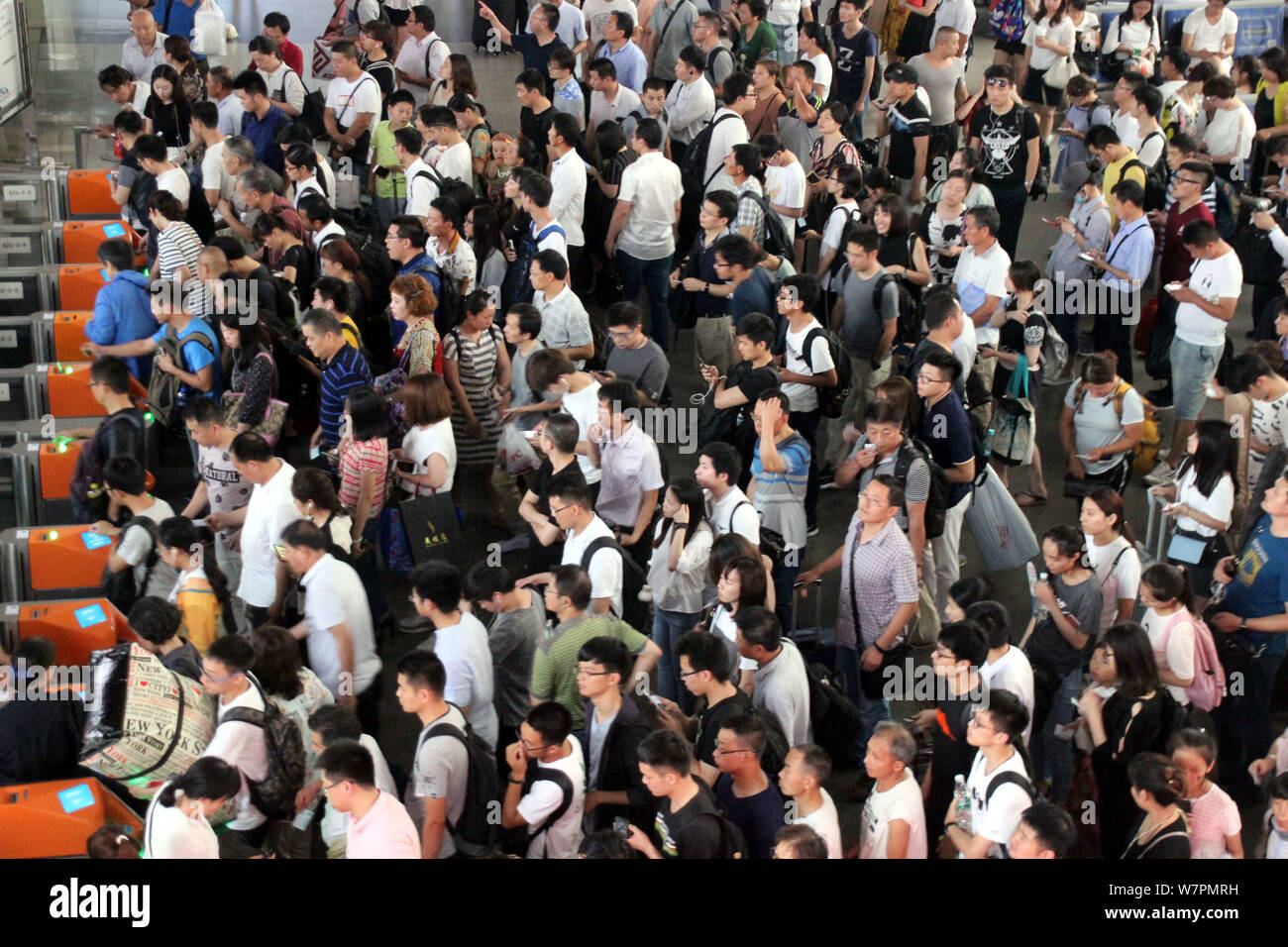 A crowd of Chinese passengers queue up to have their train tickets ...