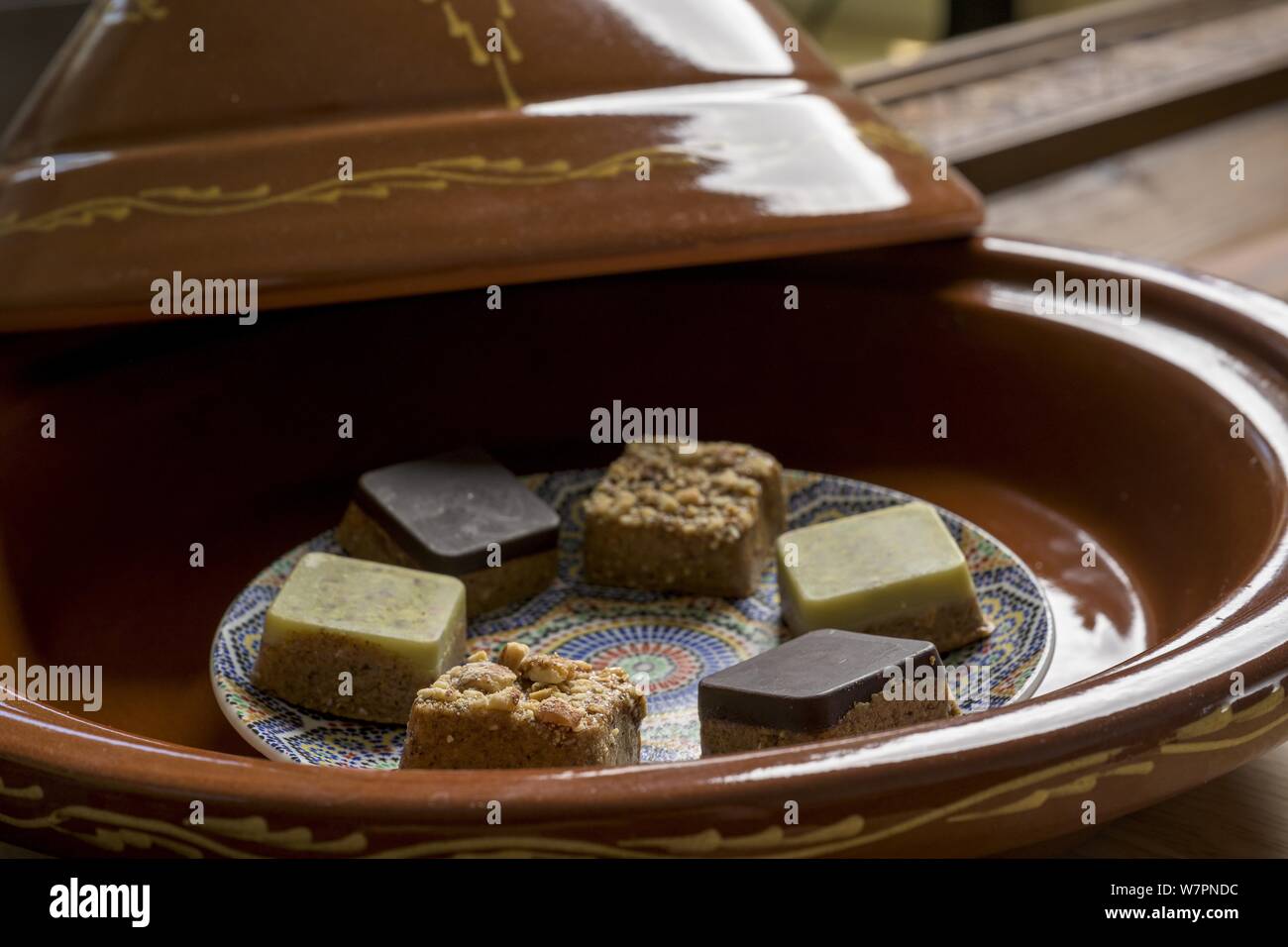 Closeup shot of different types of square-shaped sweets in a wooden ...