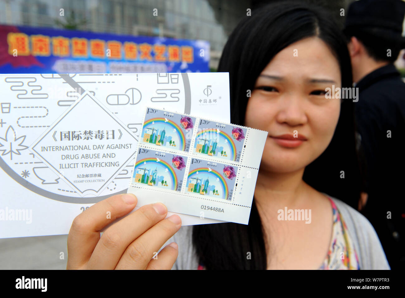 A citizen shows a piece of commemorative stamp issued for this year's ...