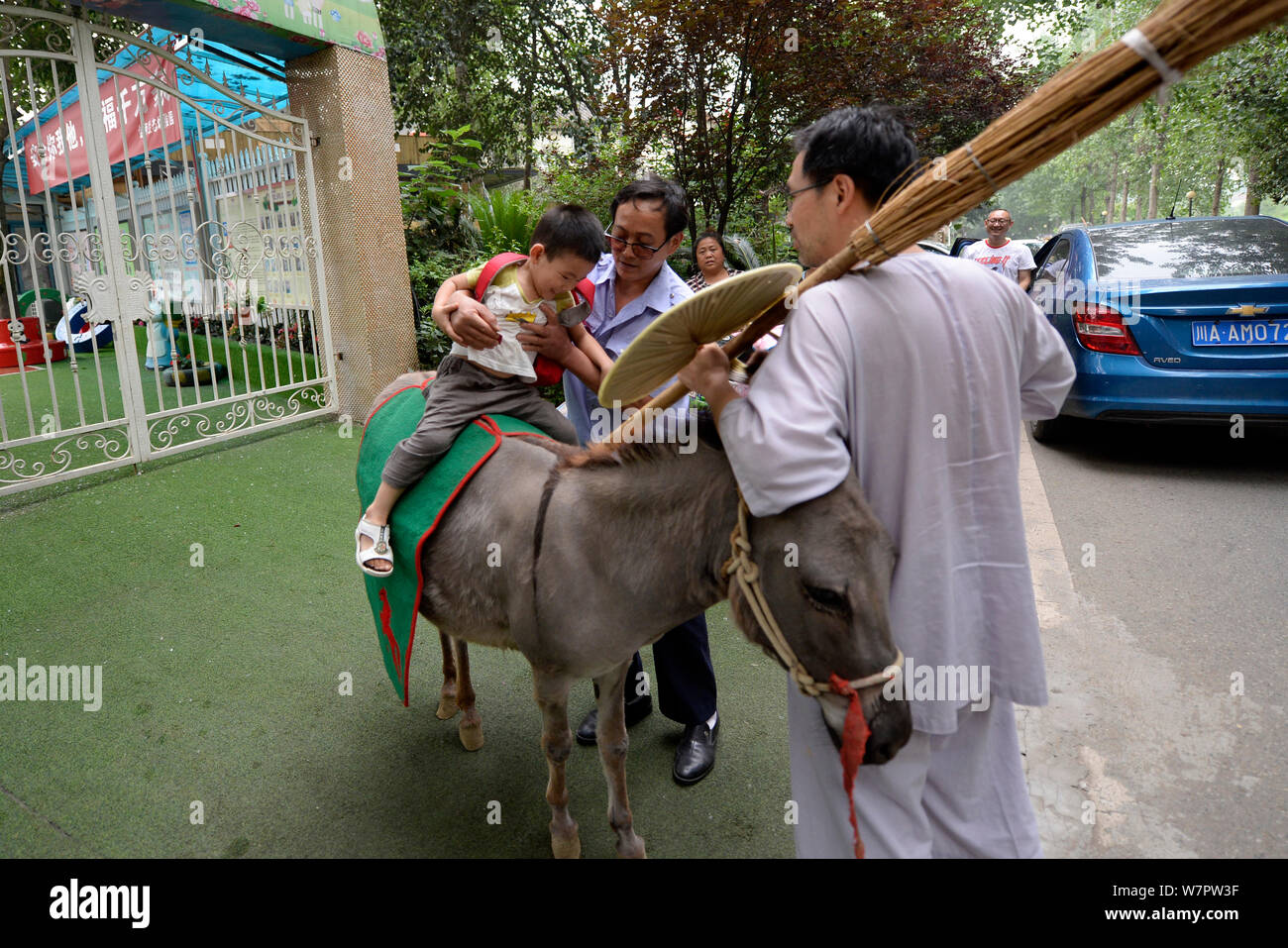 The three-year-old child is pictured on the back of a donkey with his ...