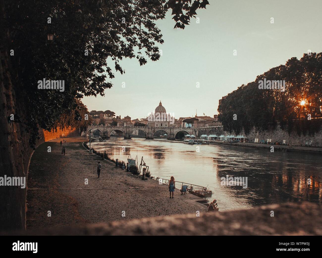 Beautiful shot of a black concrete pathway beside the body of waterin ...