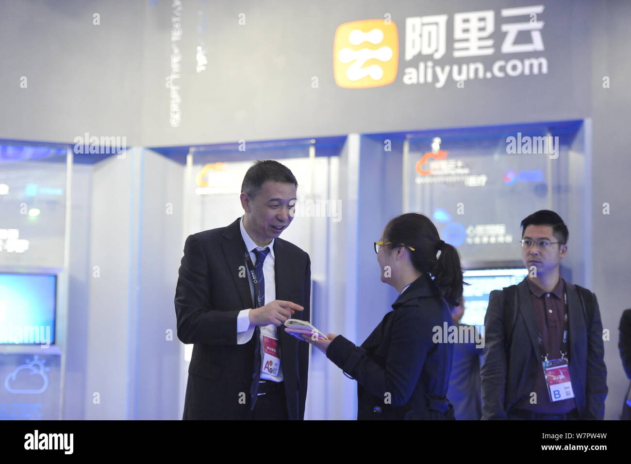 --FILE--Visitors talk at the stand of Aliyun.com, the online cloud ...