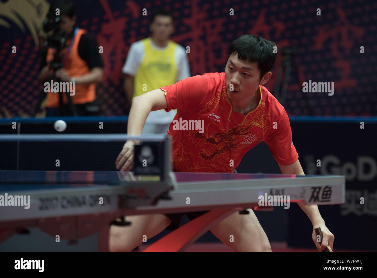 Xu Xin of China returns a shot as he and Fan Zhendong compete against ...